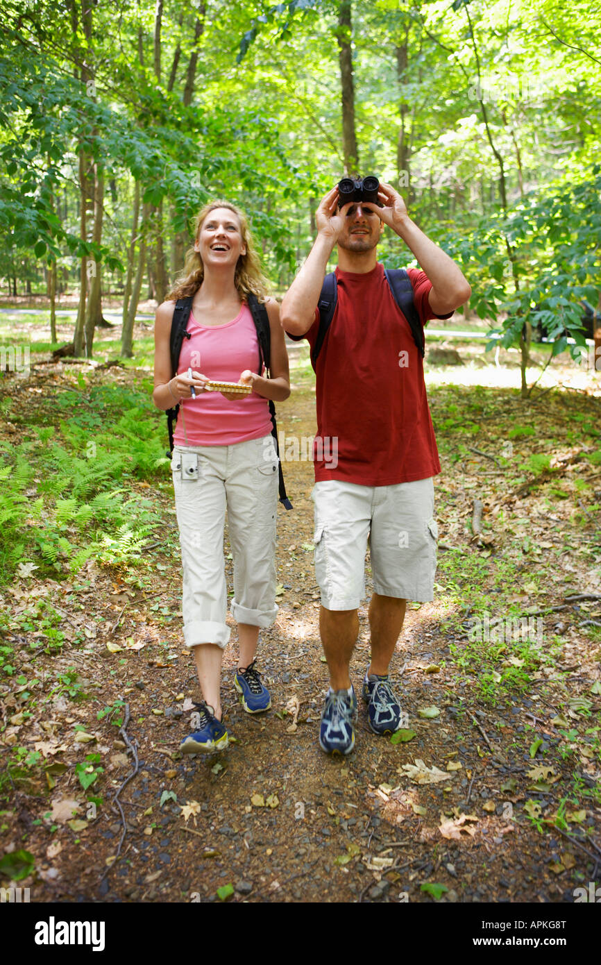 Man and woman watching birds in forest Stock Photo - Alamy