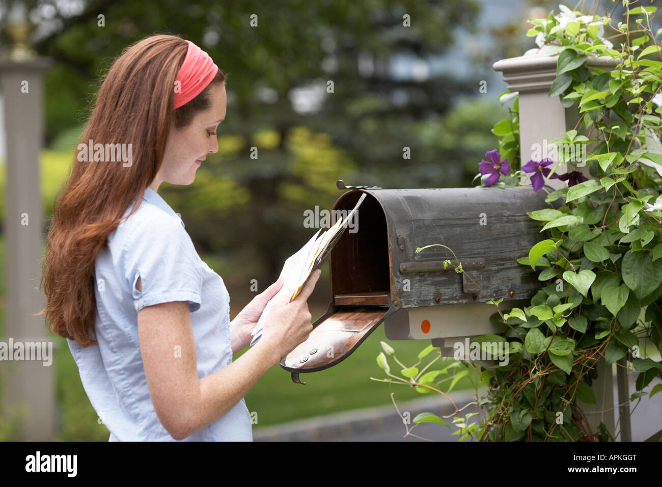 Young woman collecting post Stock Photo - Alamy