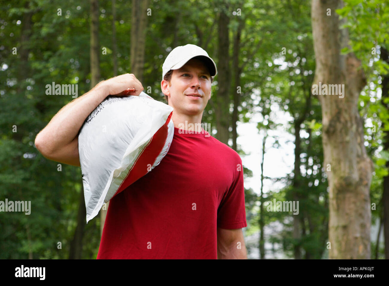 Young man carrying sack on shoulder (low angle view Stock Photo - Alamy