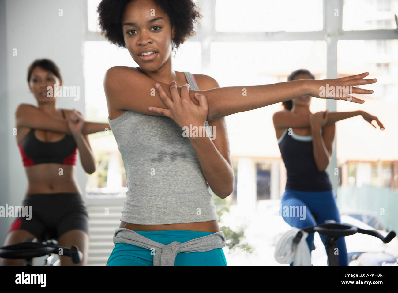 Women stretching on exercise bikes Stock Photo - Alamy