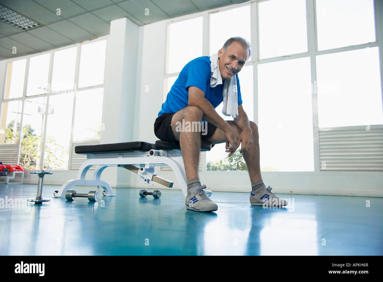 Man sitting on exercise bench Stock Photo - Alamy