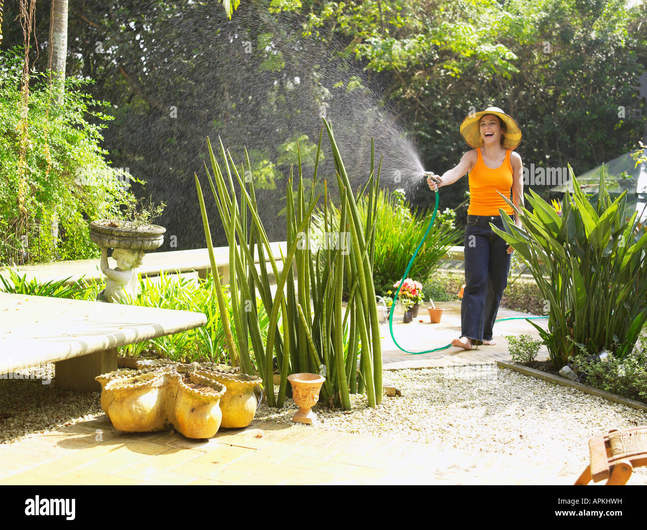 Young woman watering plants Stock Photo - Alamy