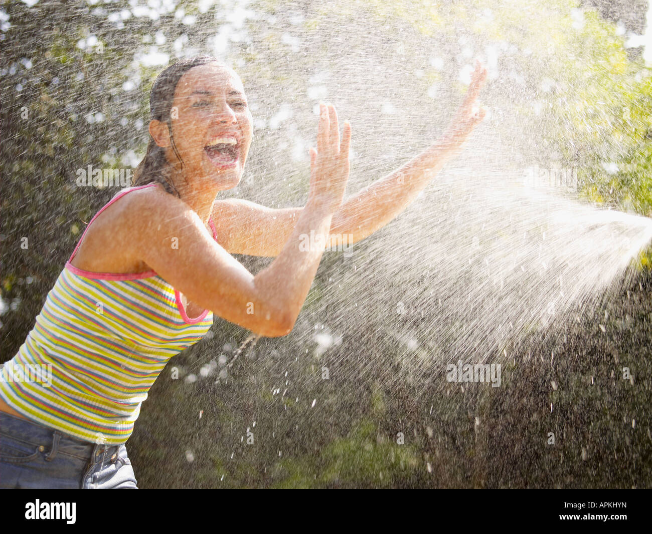 Young woman under water spray Stock Photo - Alamy