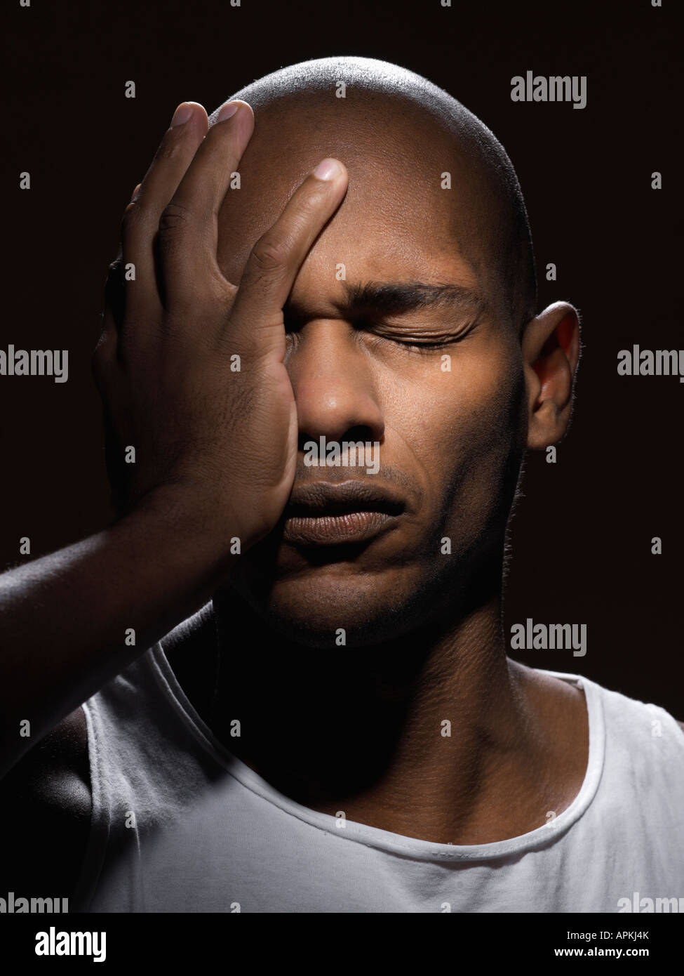 Young man with hand on face Stock Photo - Alamy