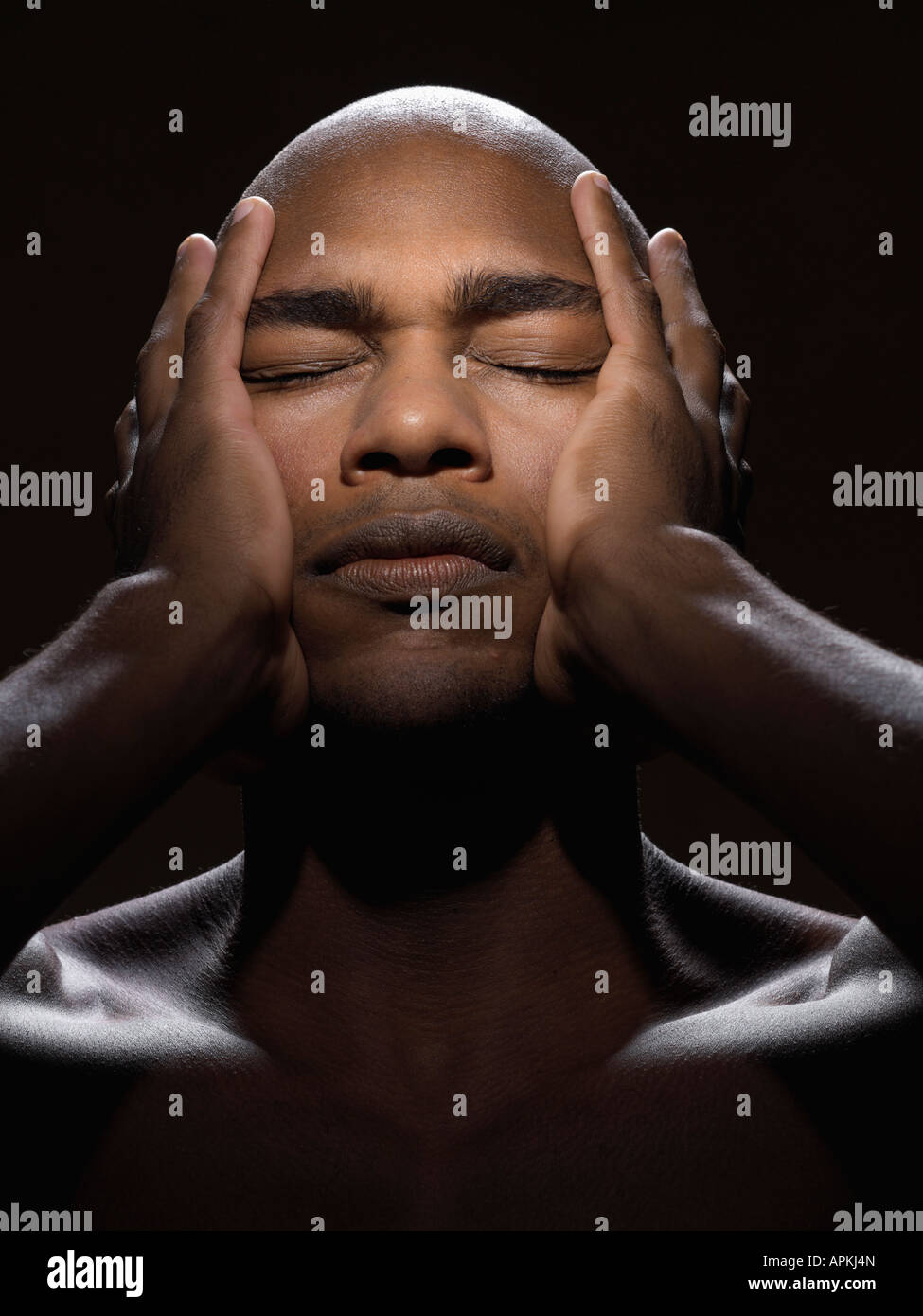 Young man holding his head Stock Photo - Alamy