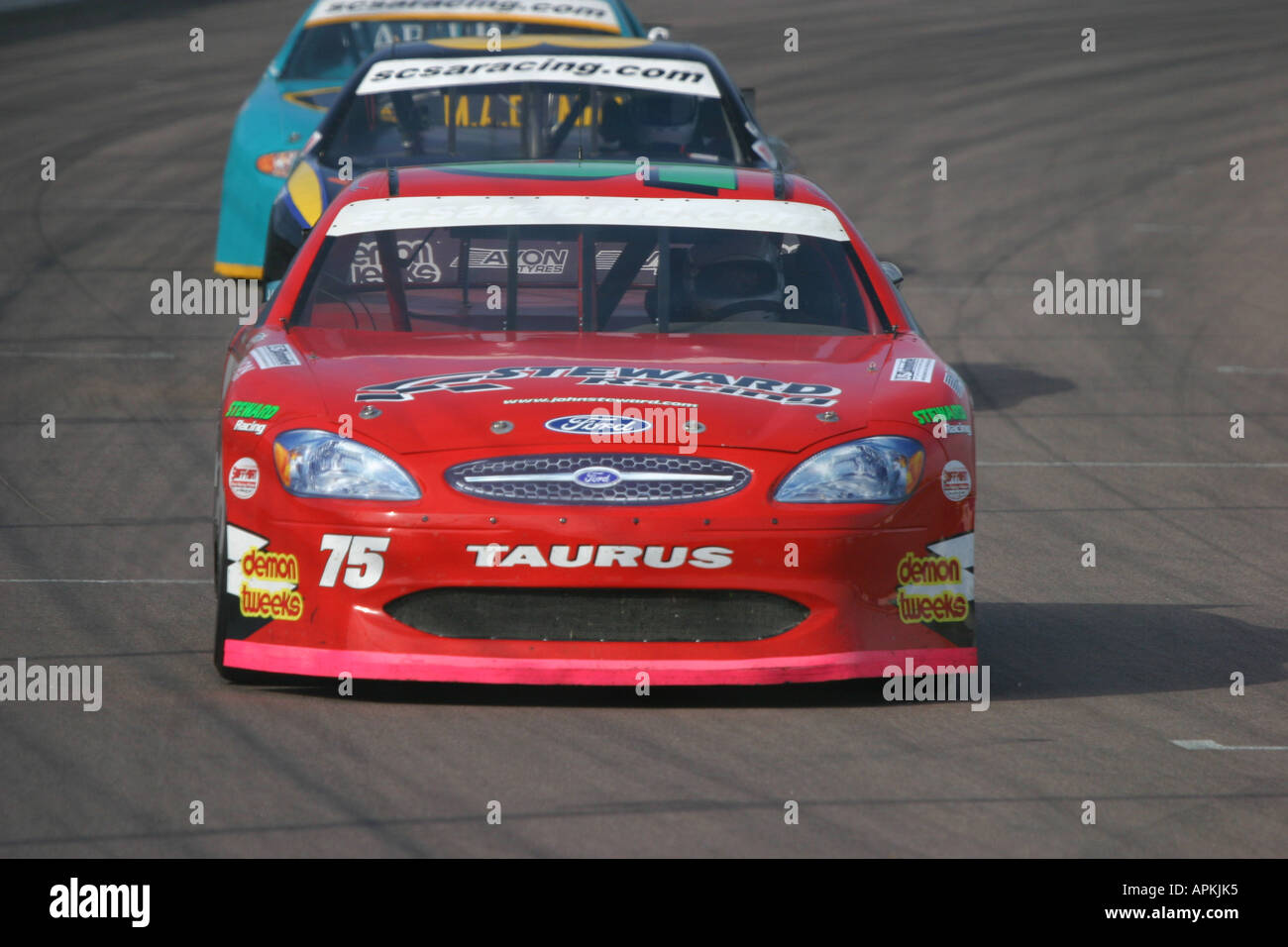 V8 Nascar type stock cars racing on a banked oval circuit Stock Photo ...