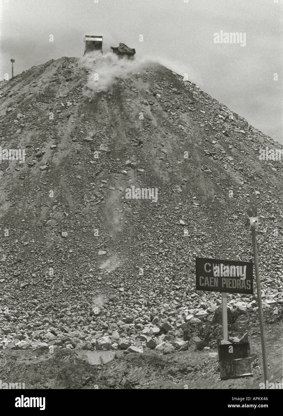 Dump trucks at Cuajone copper mine tipping overburden during ...
