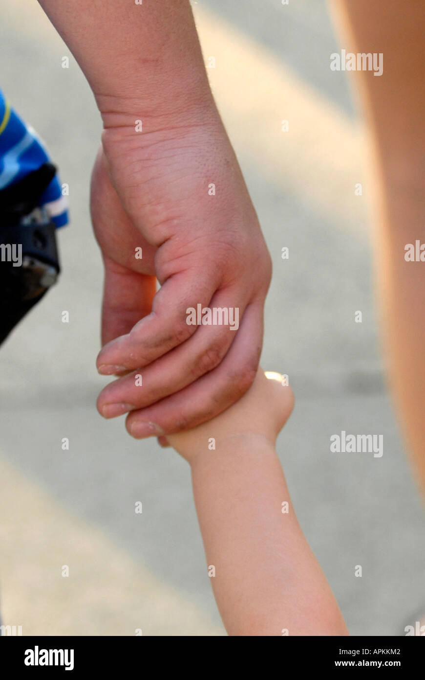 Father holds the hands of his son Stock Photo - Alamy