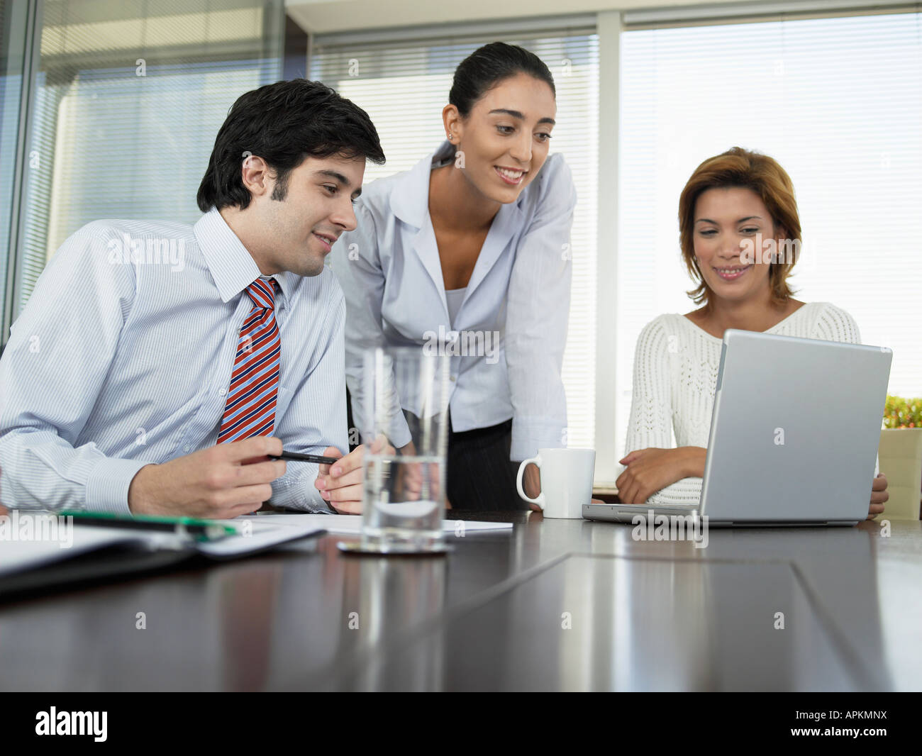 Businesspeople using laptop computer in meeting Stock Photo - Alamy