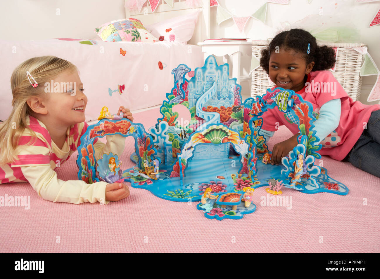 two girls play in a bedroom with a toy fantasy mermaid land Stock Photo ...