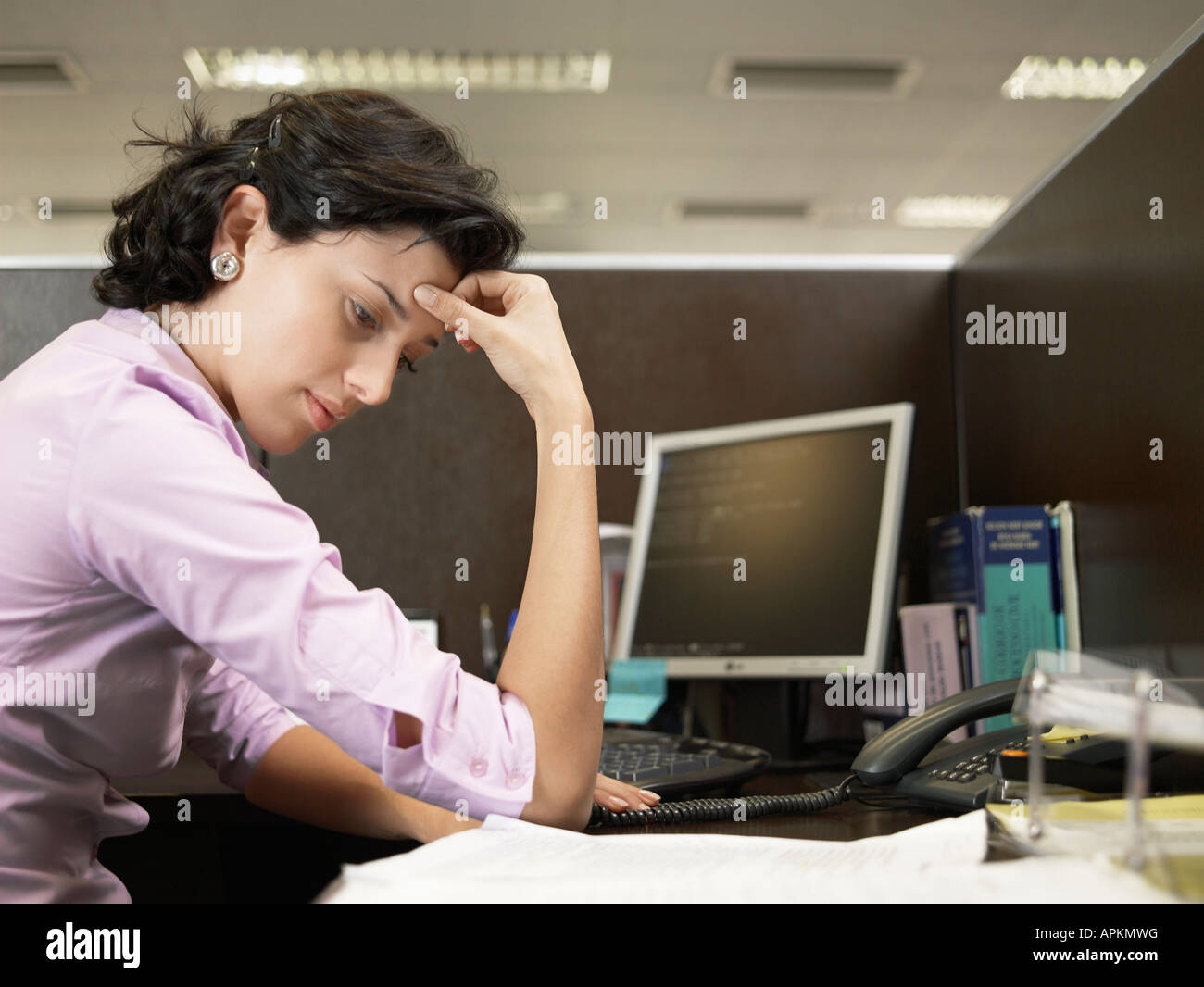 Female office worker reading documents at desk Stock Photo - Alamy