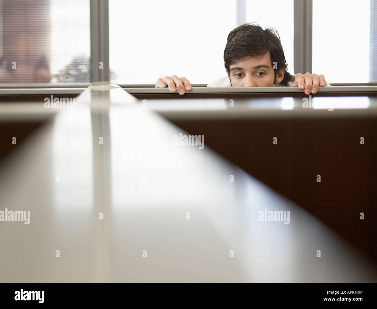 Male office worker peeping over partition wall Stock Photo - Alamy