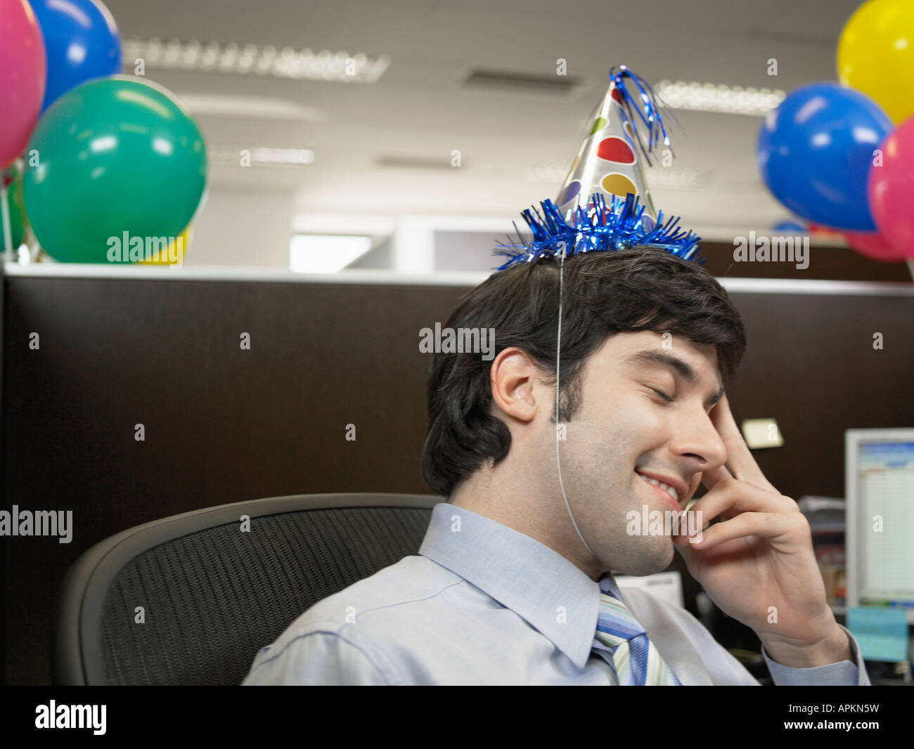 Office worker wearing party hat Stock Photo - Alamy