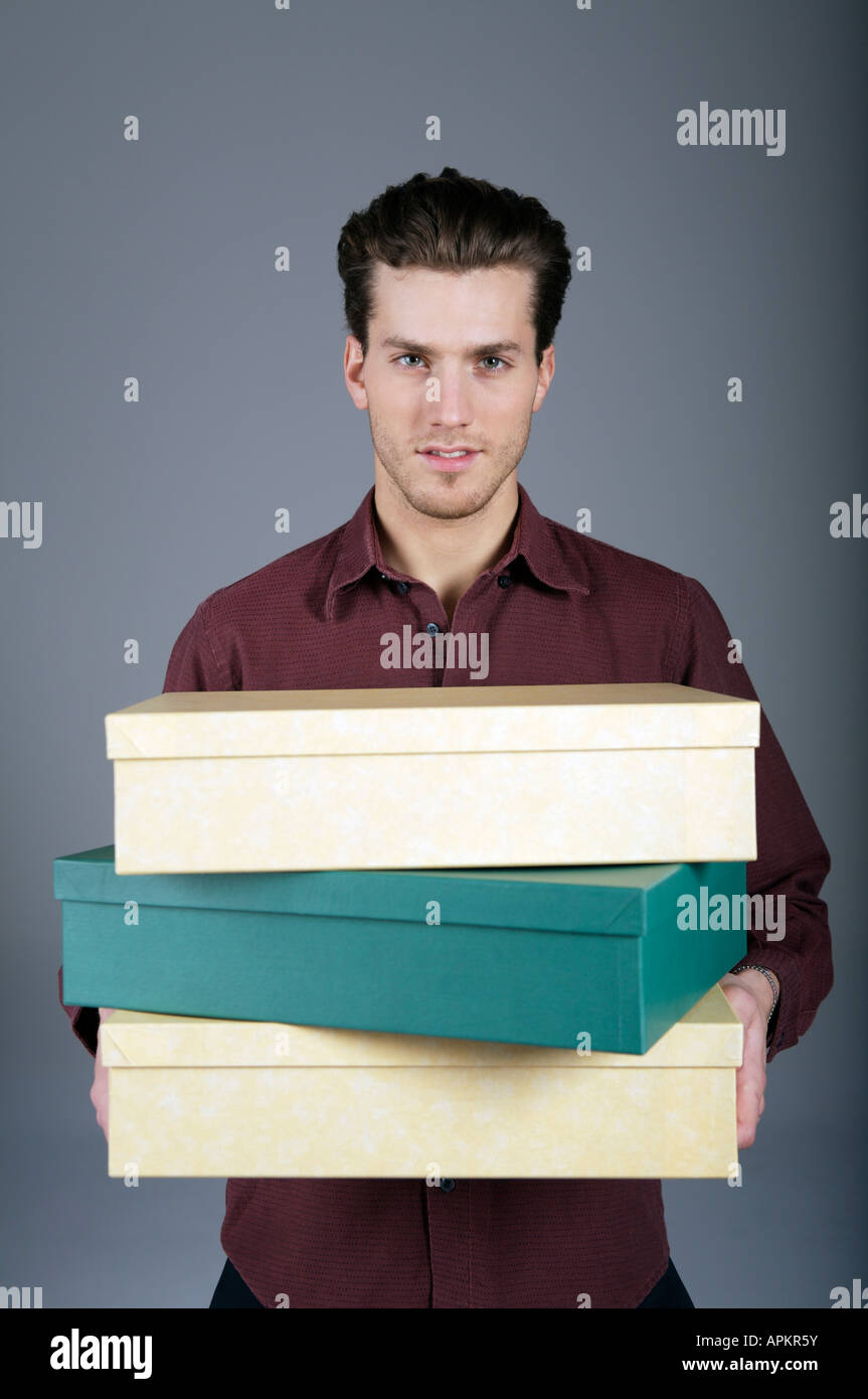 Young man holding boxes Stock Photo - Alamy