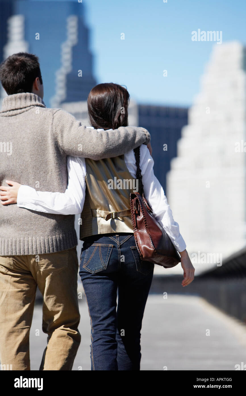 Couple walking with arms around each other (rear view Stock Photo - Alamy
