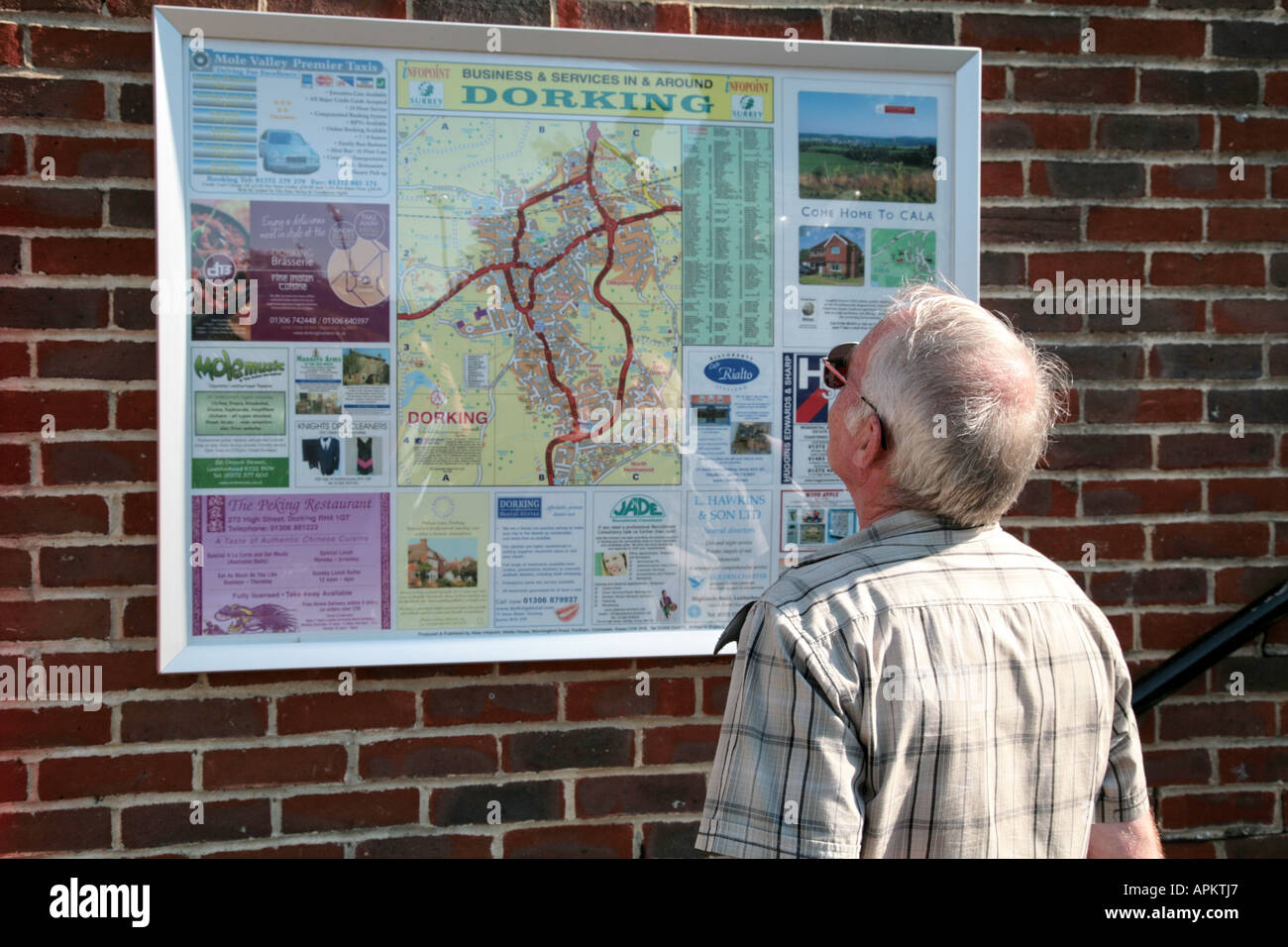 Man checking town map of Dorking Stock Photo - Alamy