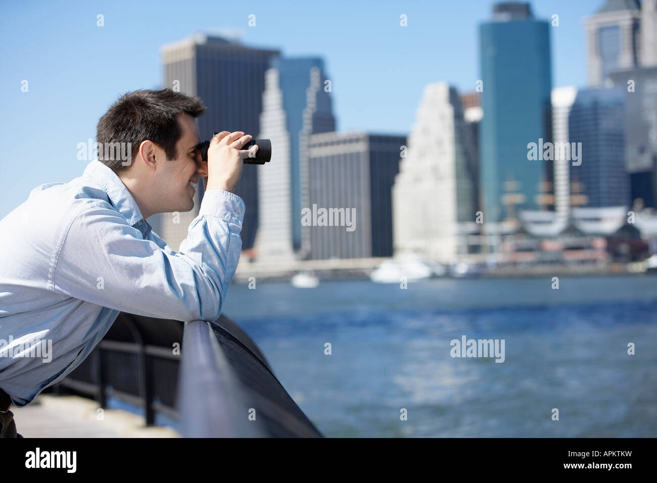 Man using binoculars, Manhattan in background, New York City, New York ...
