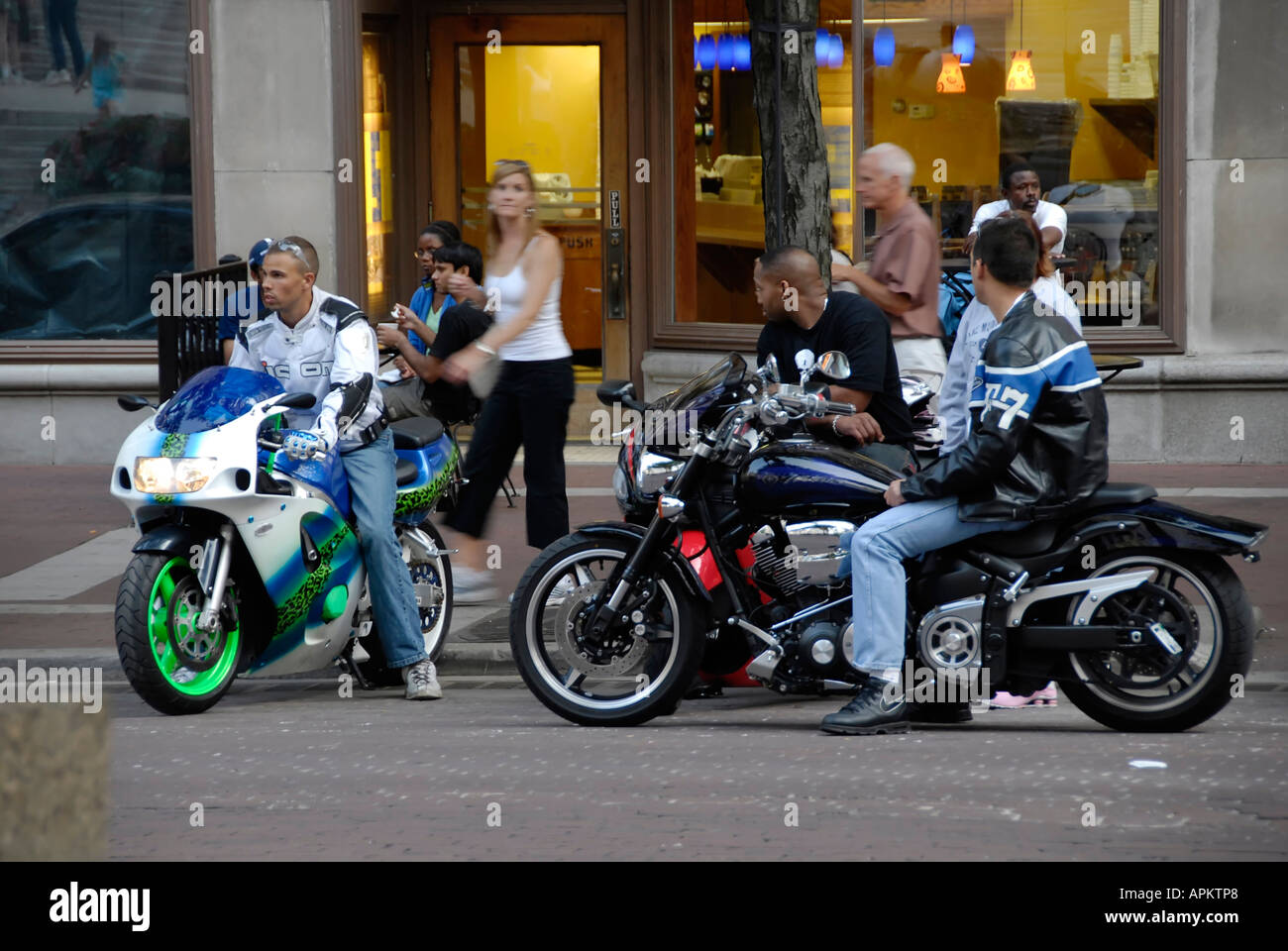 Teenage kids hang out together on motorcycles at night in downtown ...