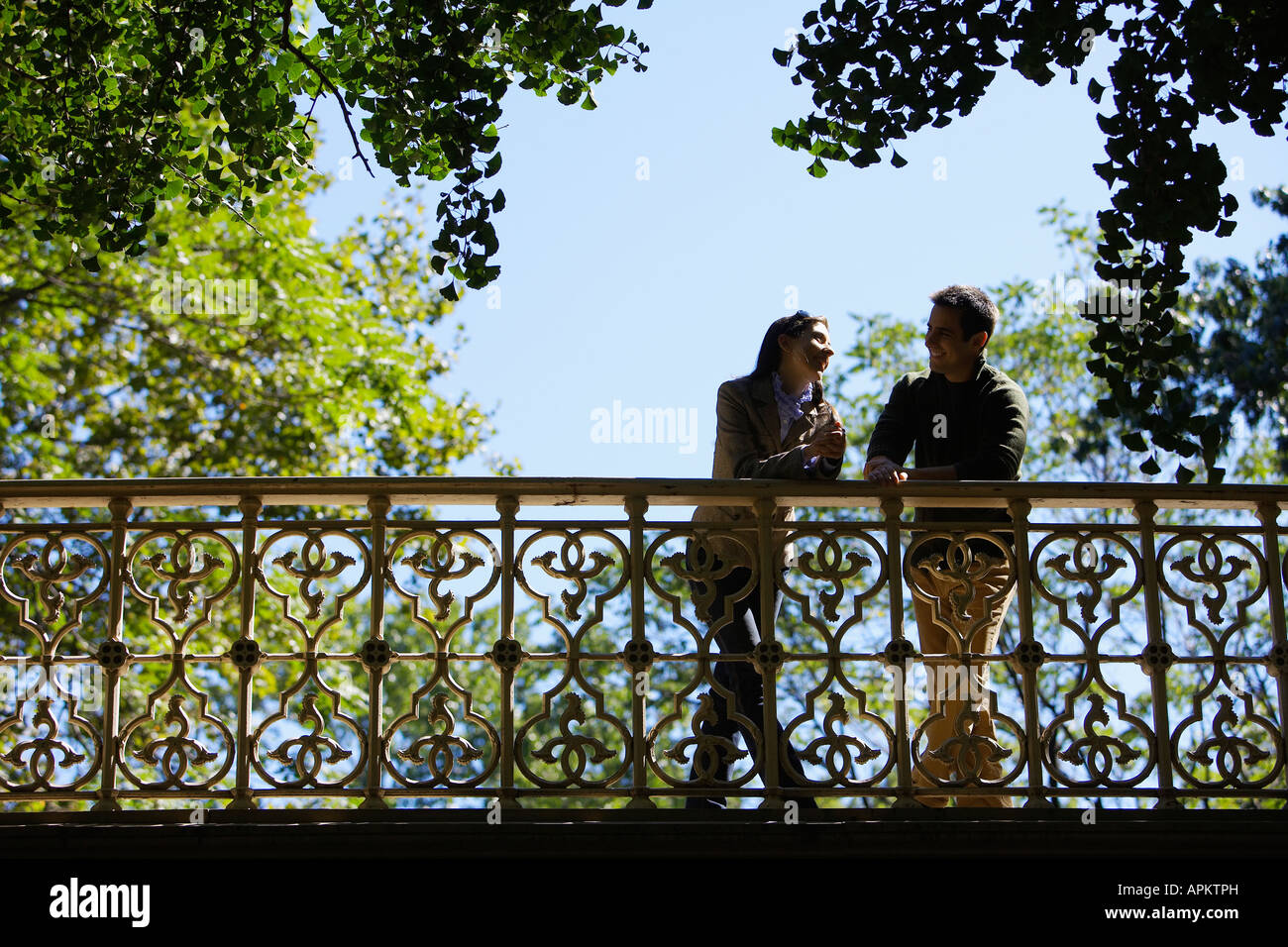 Couple talking on bridge (low angle view Stock Photo - Alamy