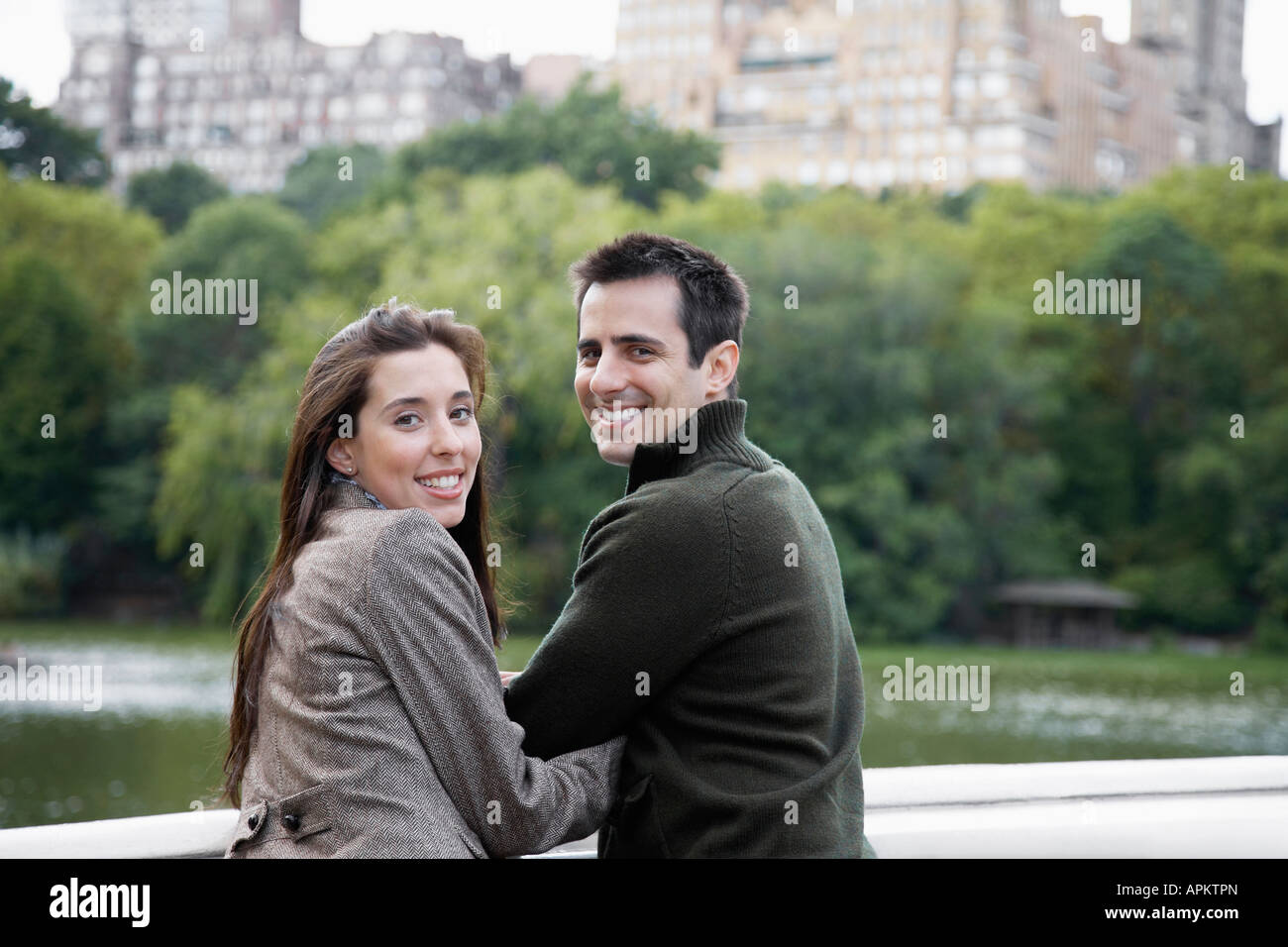 Young couple looking over shoulder by pond Stock Photo - Alamy