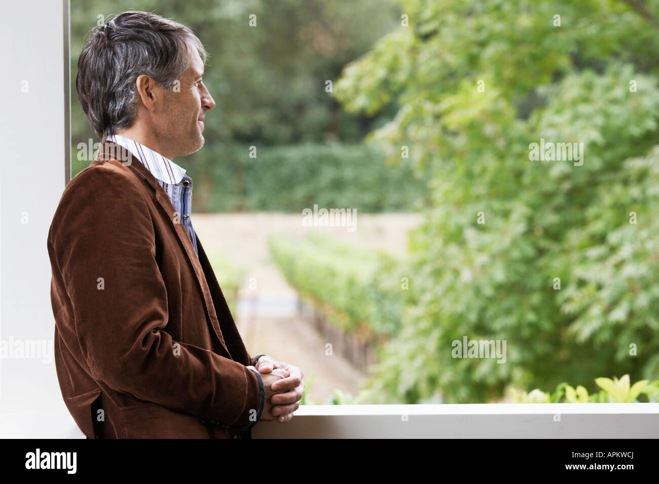 Mid adult man leaning on railing Stock Photo - Alamy