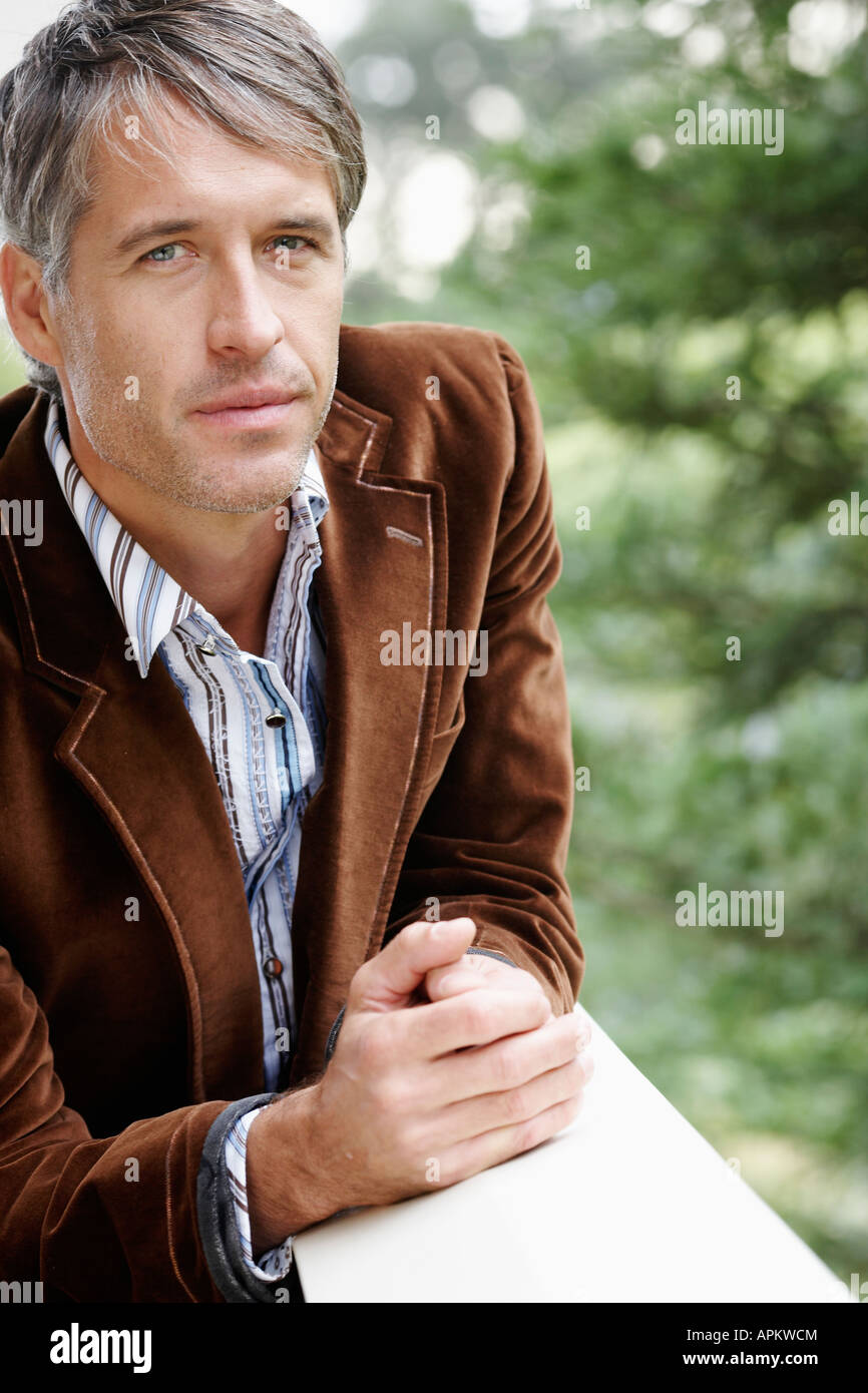 Mid adult man leaning on railing (portrait Stock Photo - Alamy