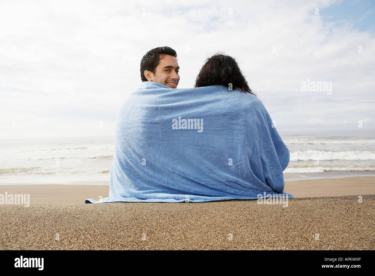 Young couple wrapped in towel on beach (rear view Stock Photo - Alamy