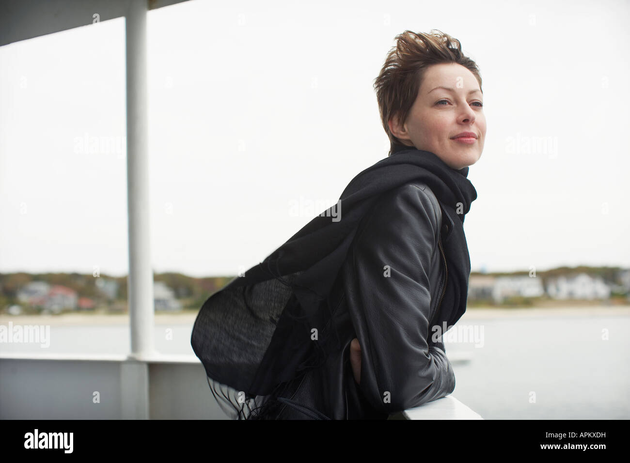 Woman leaning on railing and looking at view Stock Photo - Alamy