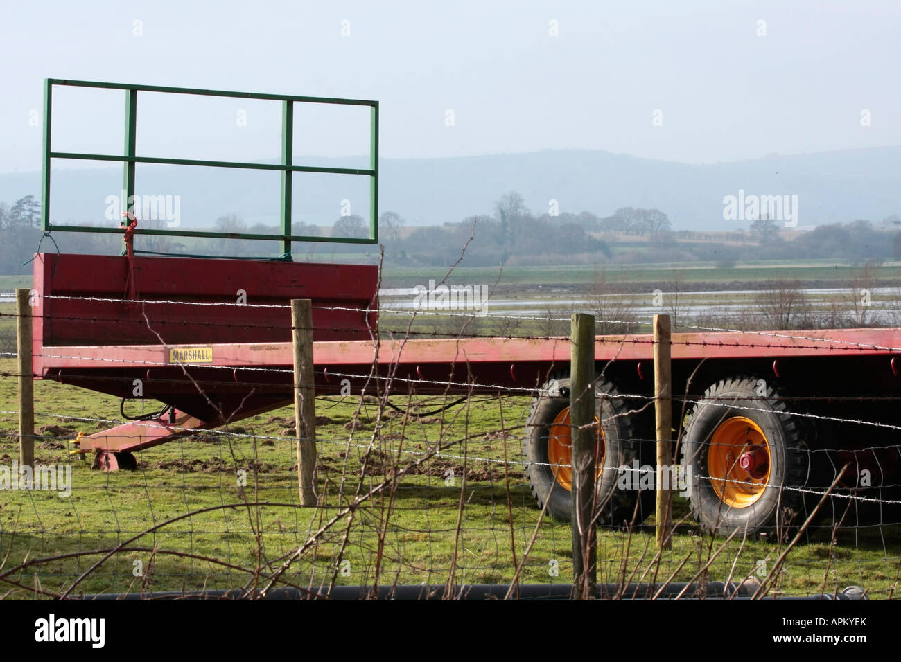 Large red flatbed trailer on farm land in winter. West Sussex, England ...