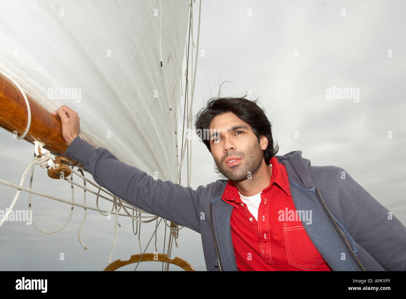 Man leaning on sail boom Stock Photo - Alamy