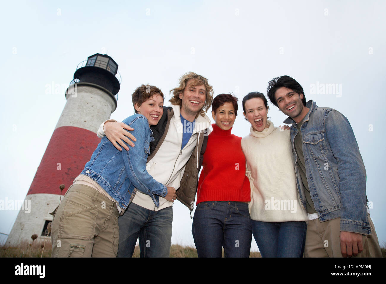 Five people hugging by lighthouse (portrait, low angle view Stock Photo ...