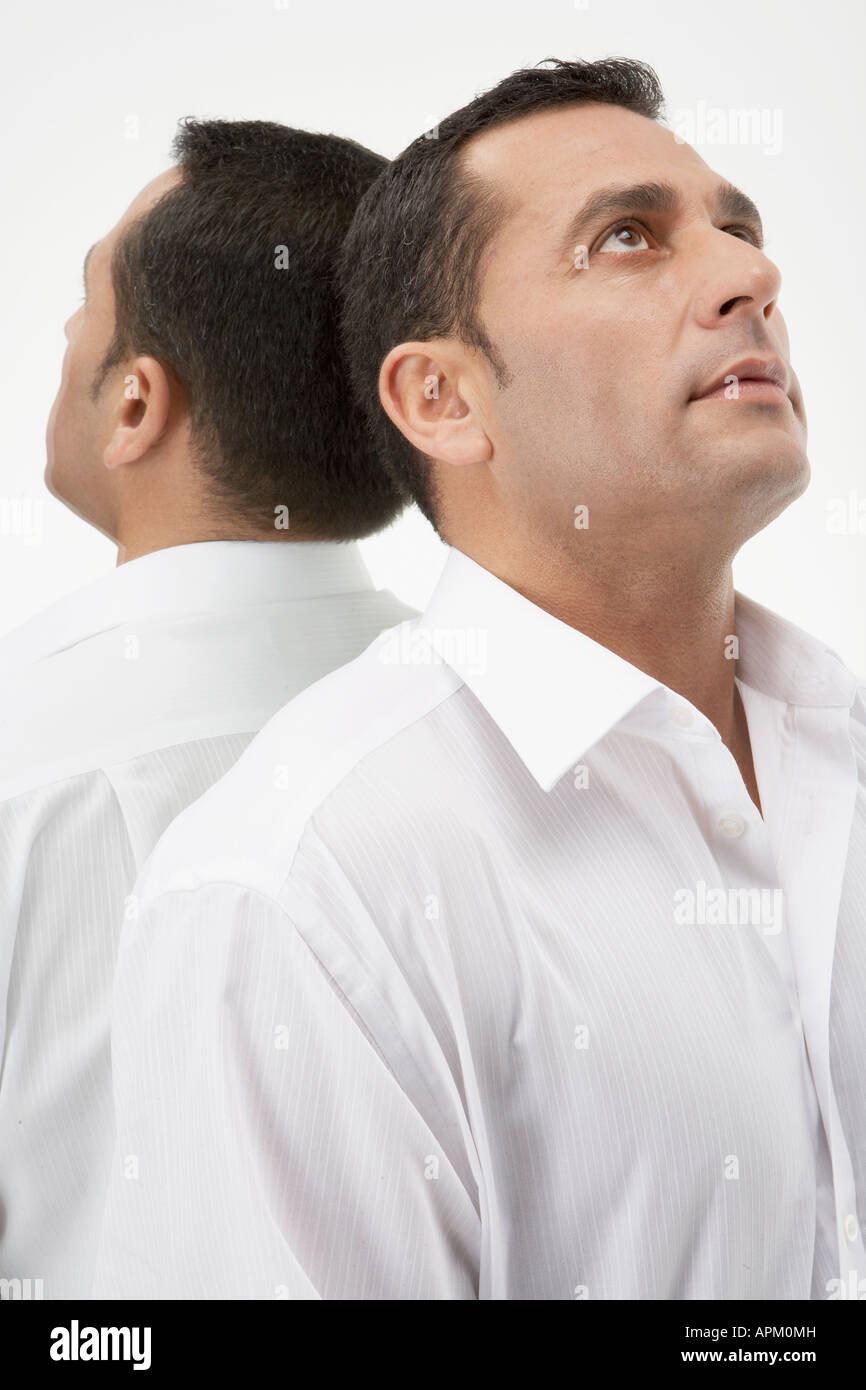 Mid adult man leaning on mirror, looking up Stock Photo - Alamy