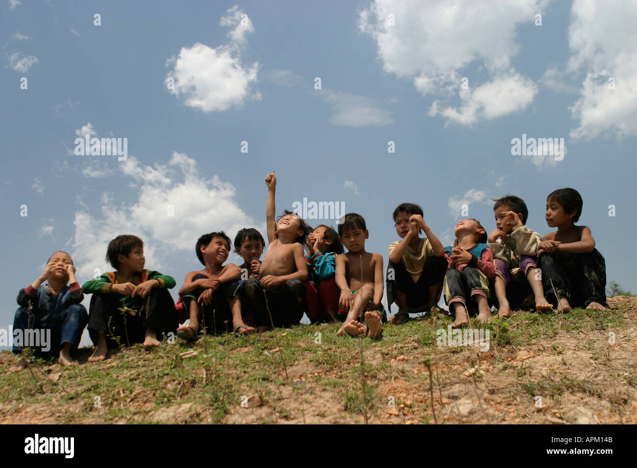 group of children under blue skies looking up Stock Photo - Alamy