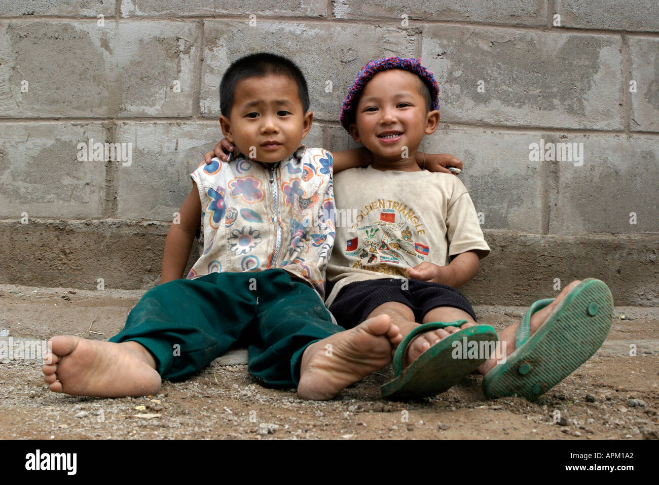 two boys hug against brick wall Stock Photo - Alamy