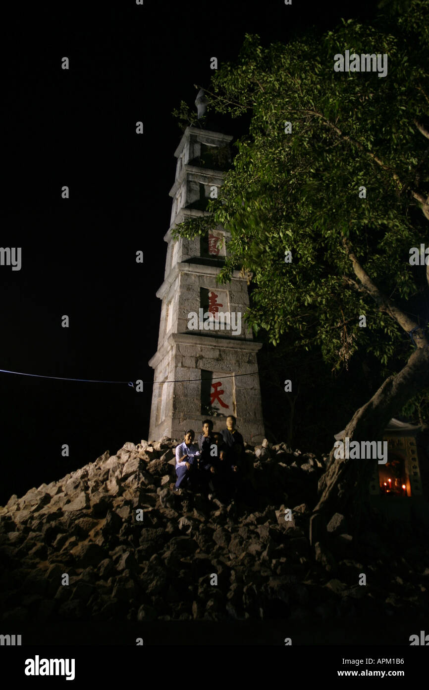 three children sit under tower at night Stock Photo - Alamy