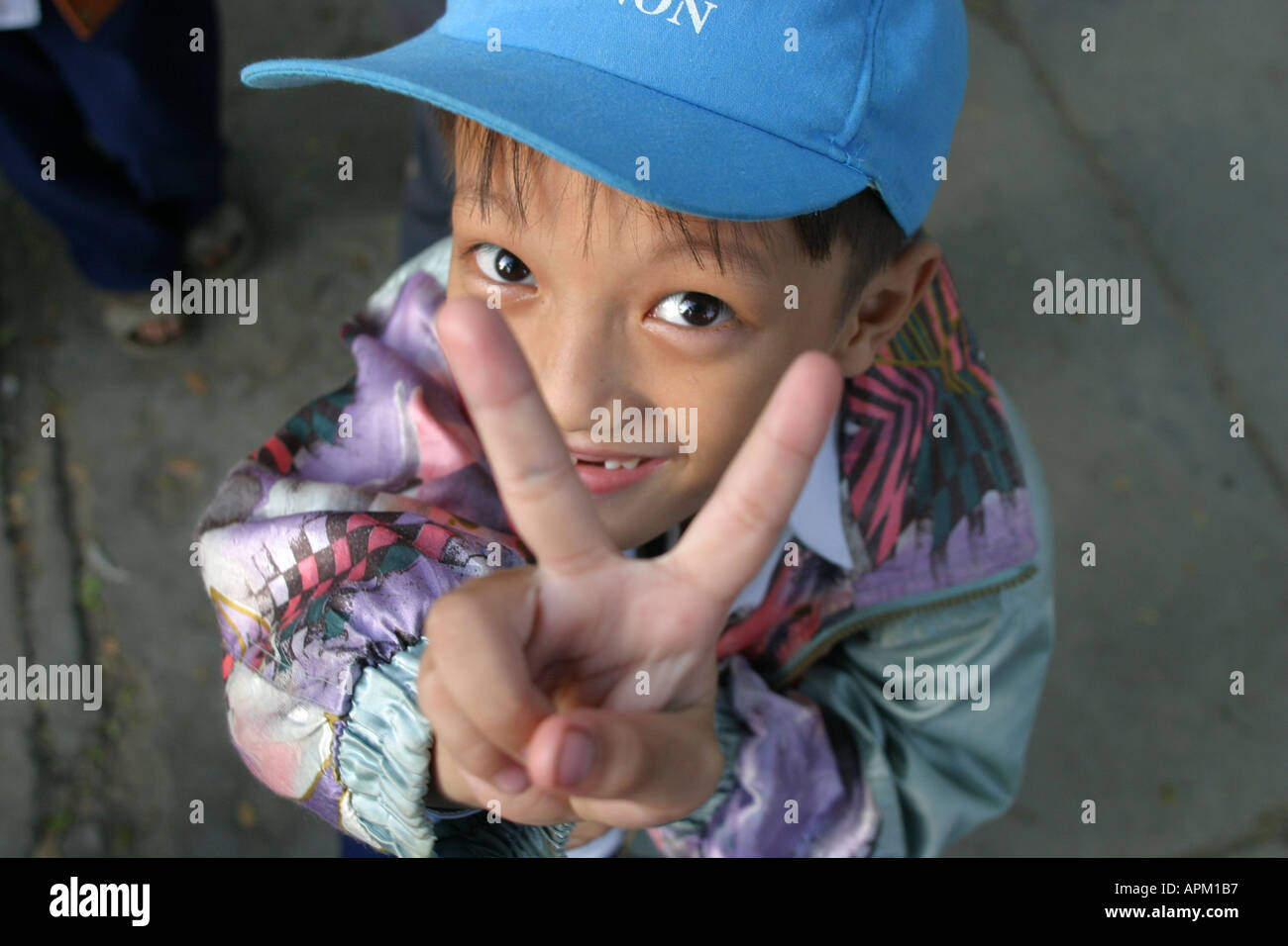 boy with cap makes peace sign Stock Photo - Alamy