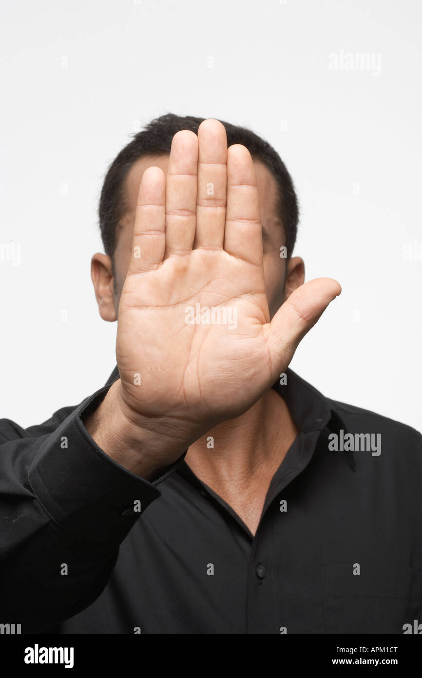 Mid adult man holding hand in front of his face, portrait Stock Photo ...