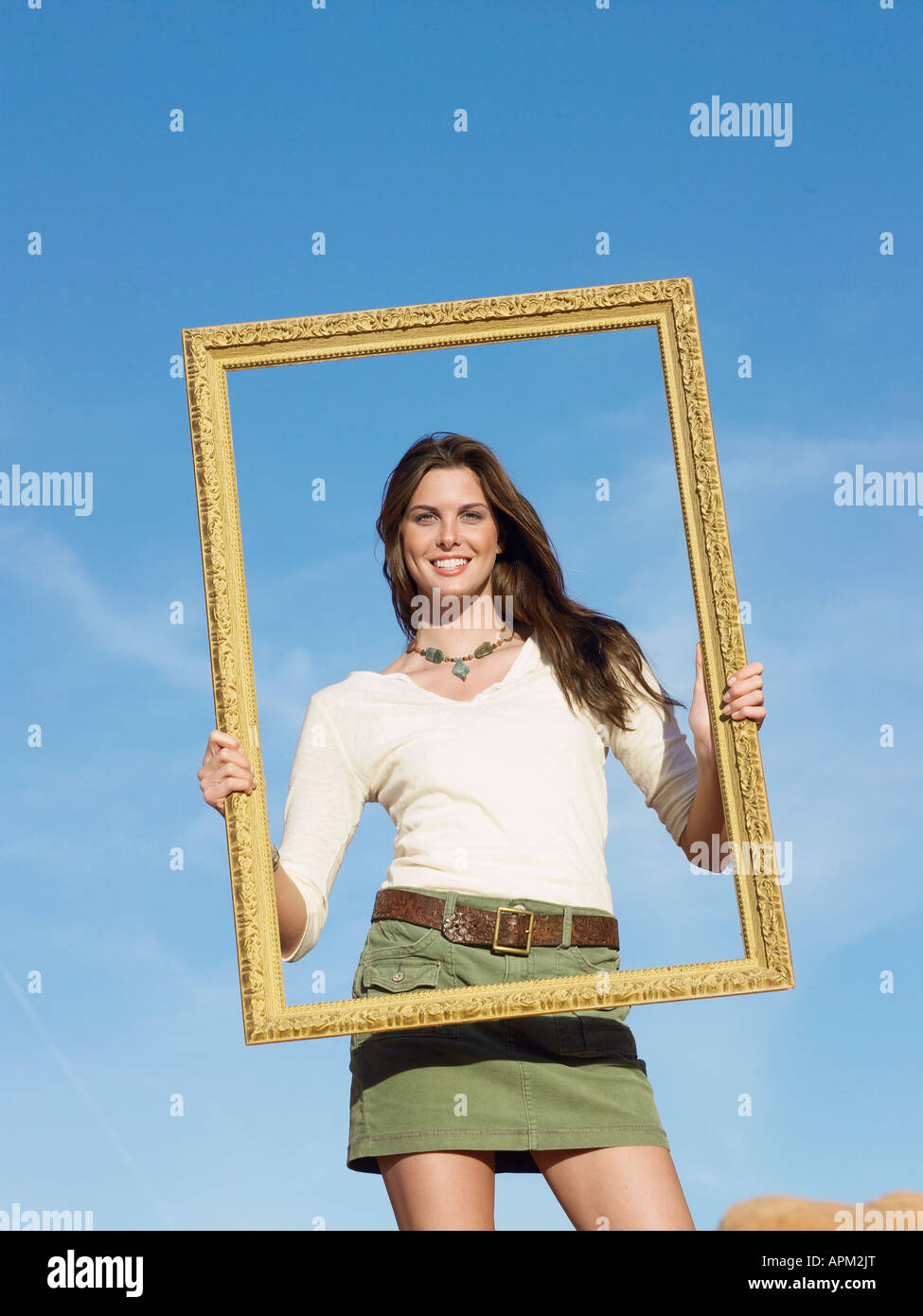 Young woman looking through picture frame, portrait Stock Photo - Alamy