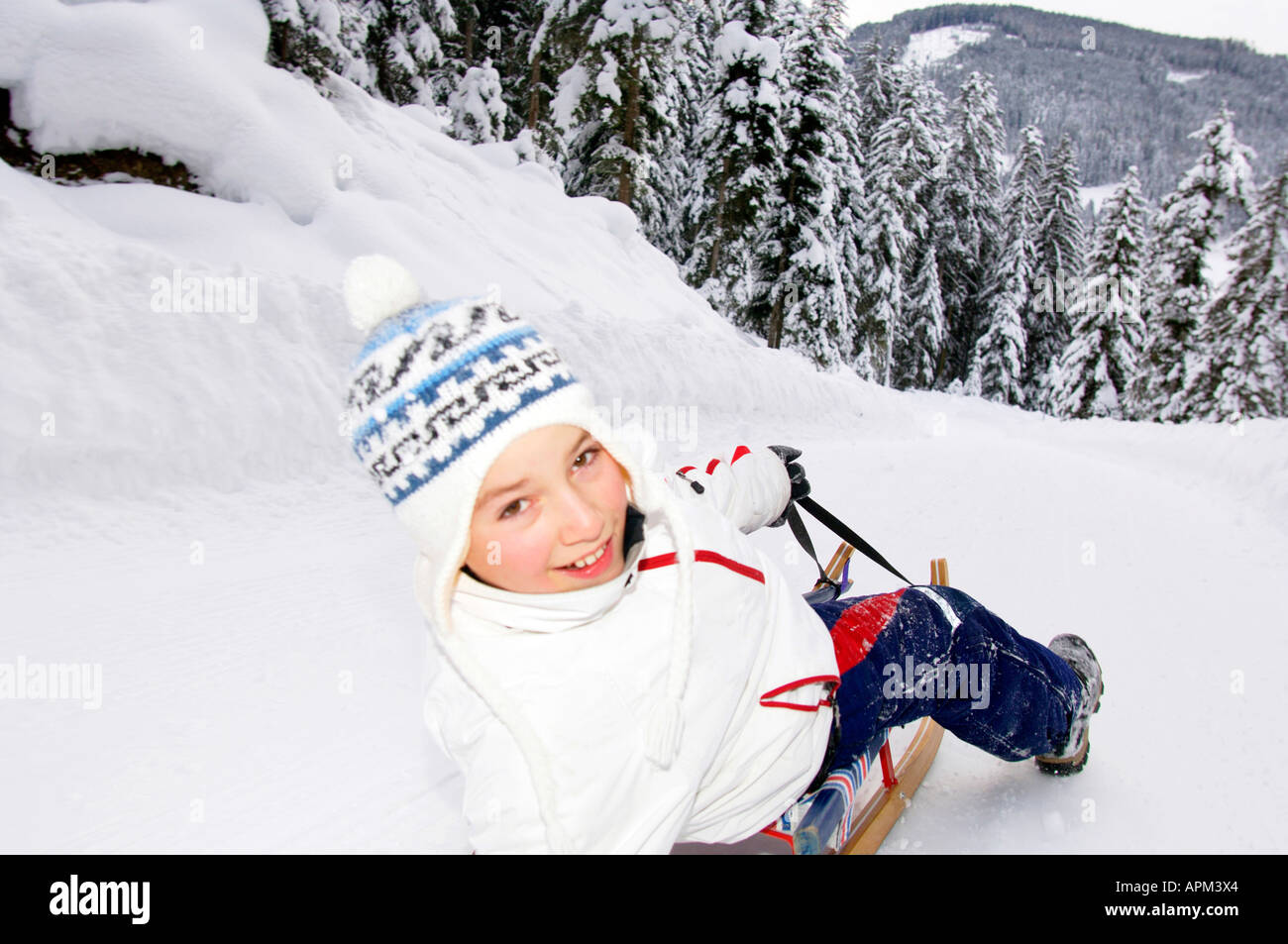 Boy on sledge, smiling, portrait Stock Photo - Alamy