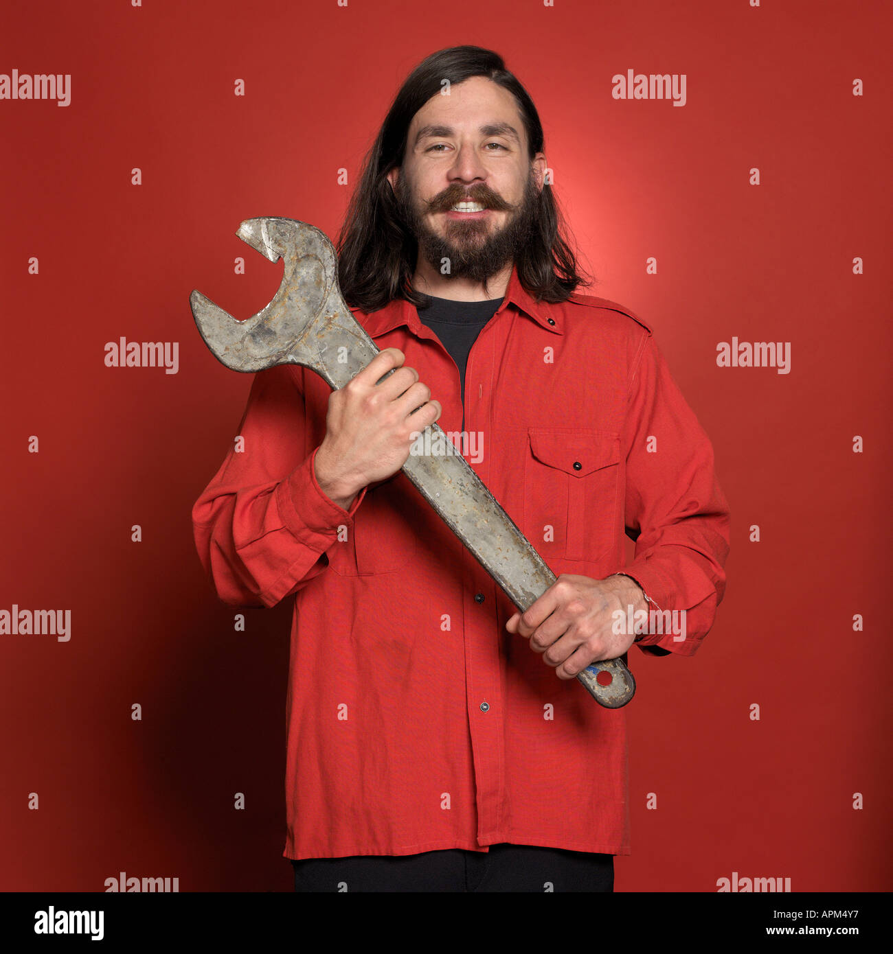Mature man holding spanner, portrait Stock Photo - Alamy