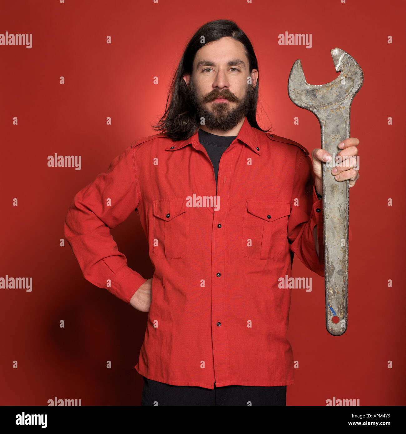 Mature man holding spanner, portrait Stock Photo - Alamy