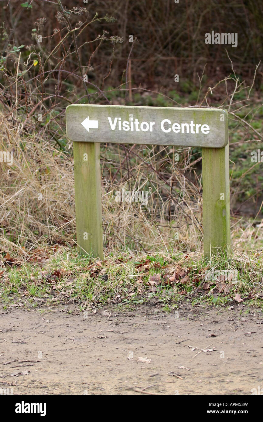 A wooden sign on nature trail pointing to Visitor Centre. Sussex ...