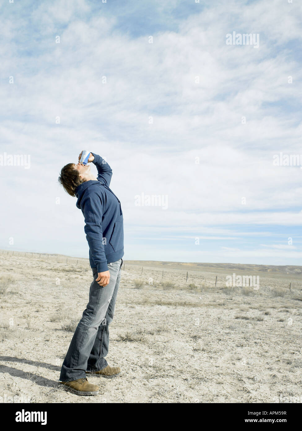 Mid adult man drinking beer in desert Stock Photo - Alamy