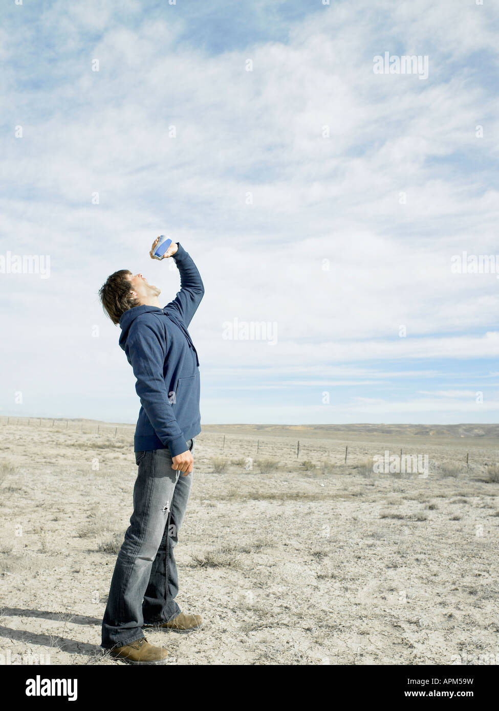 Mid adult man drinking beer in desert Stock Photo - Alamy