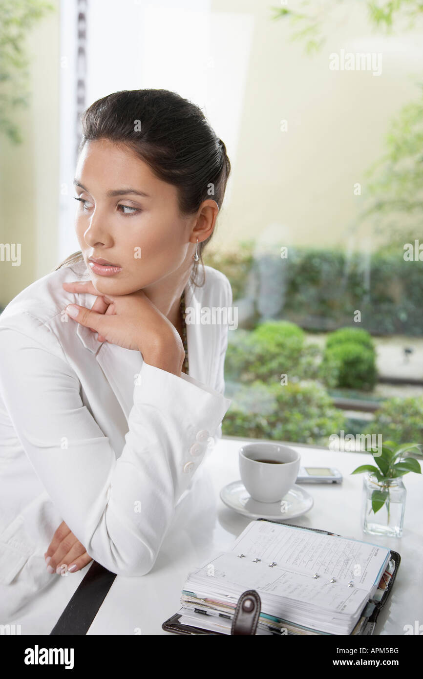 Young woman with organizer at coffee table Stock Photo - Alamy