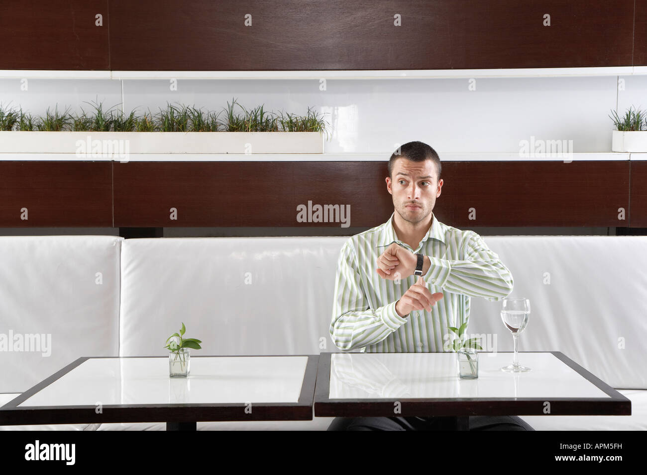 Businessman checking time in restaurant Stock Photo - Alamy