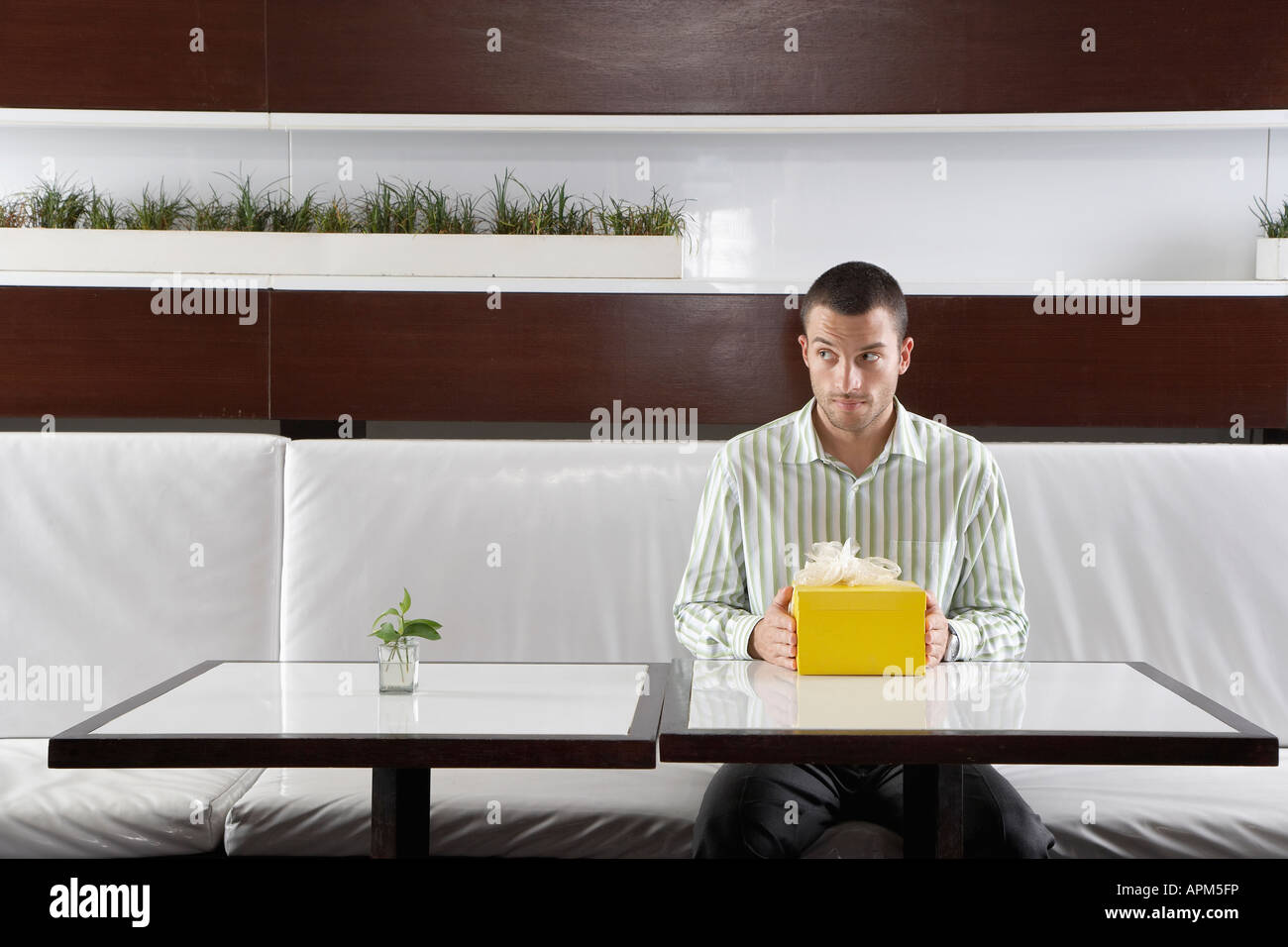 Man with present waiting in restaurant Stock Photo - Alamy