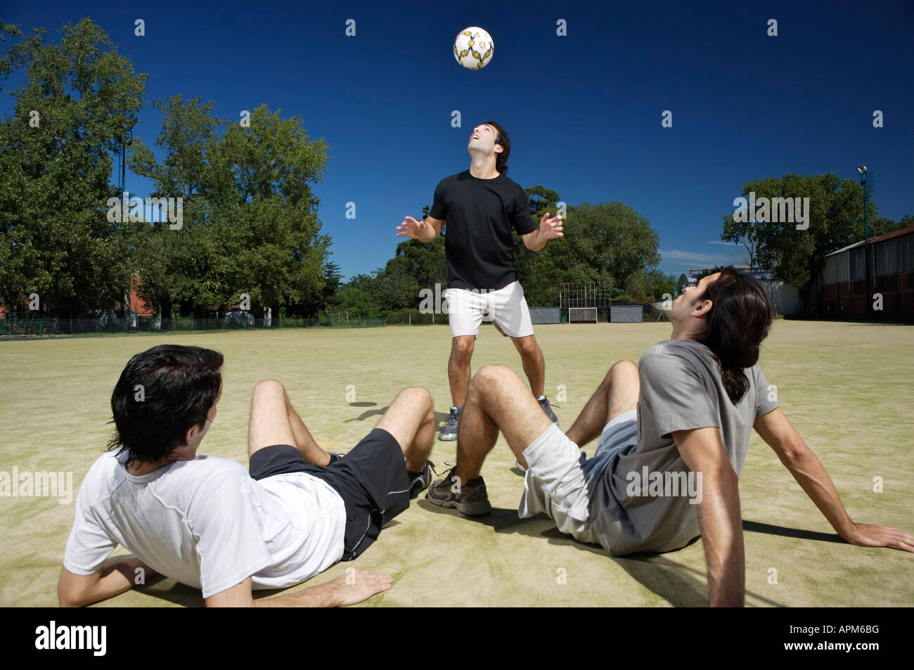 Friends playing football Stock Photo - Alamy