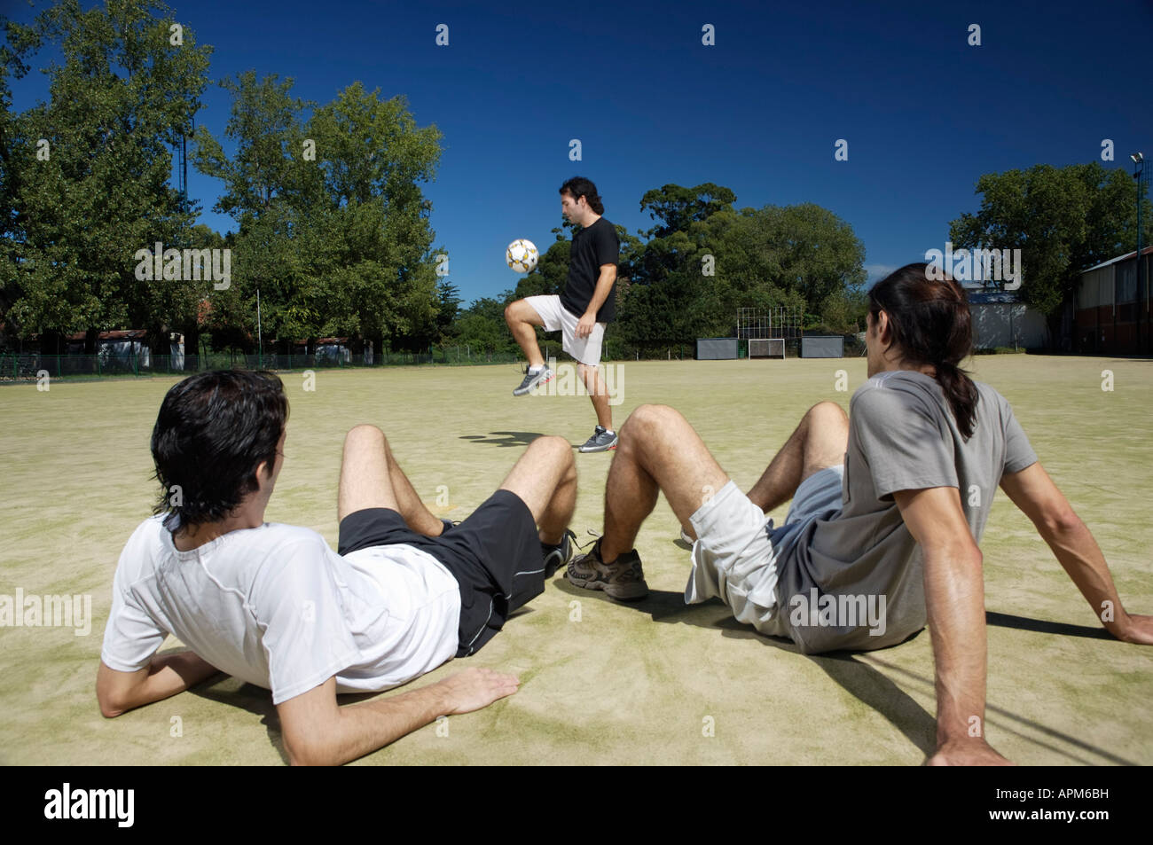 Friends playing football Stock Photo - Alamy