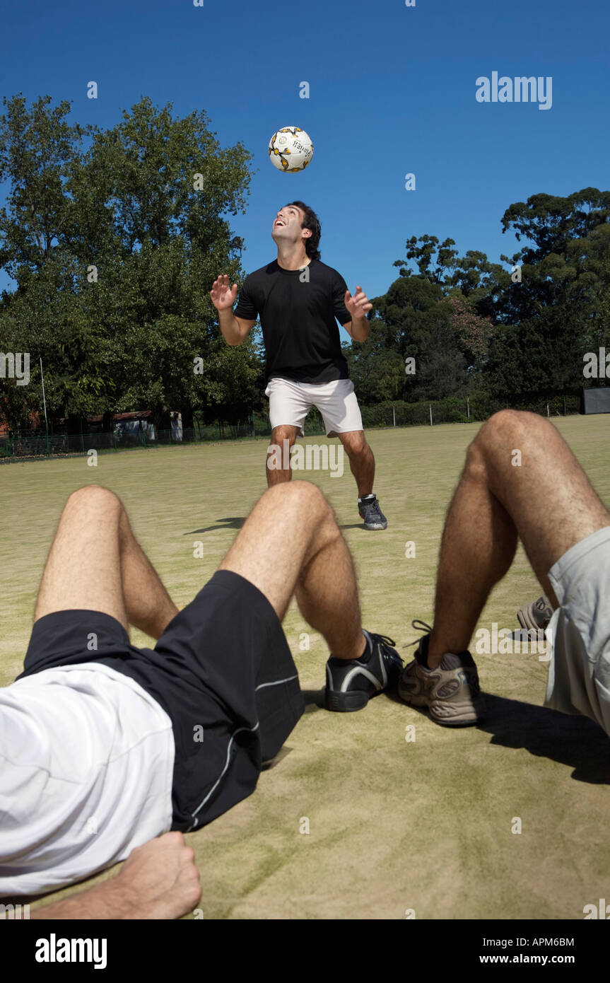 Friends playing football Stock Photo - Alamy